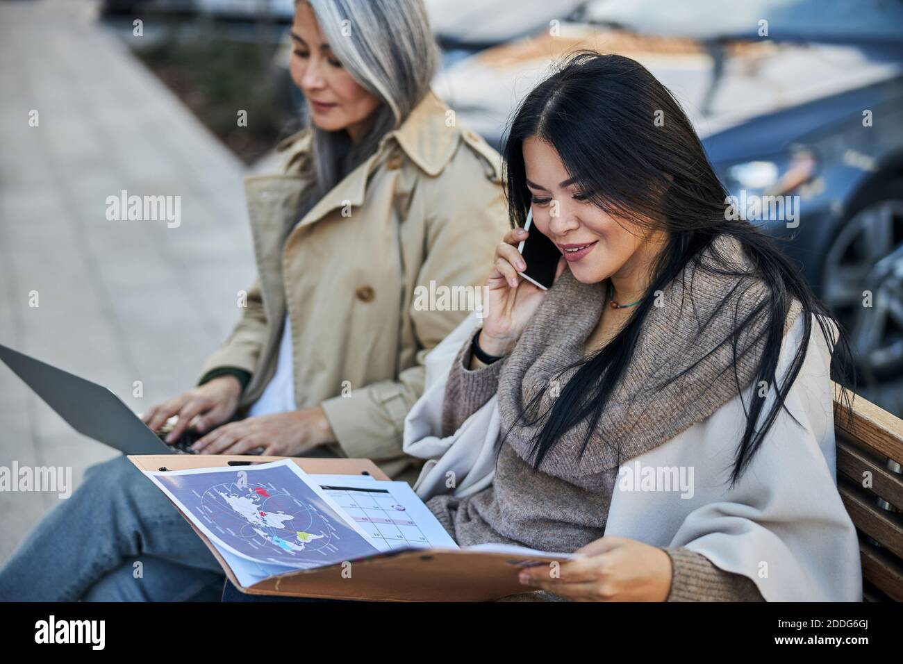 Two beautiful women working on project on the street Stock Photo - Alamy