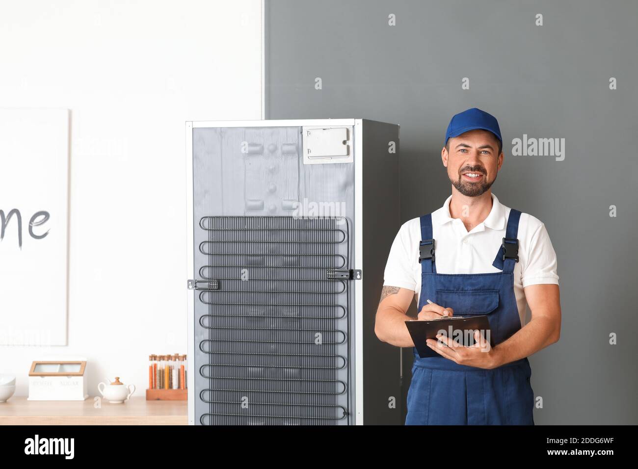 Worker of repair service near fridge in kitchen Stock Photo - Alamy