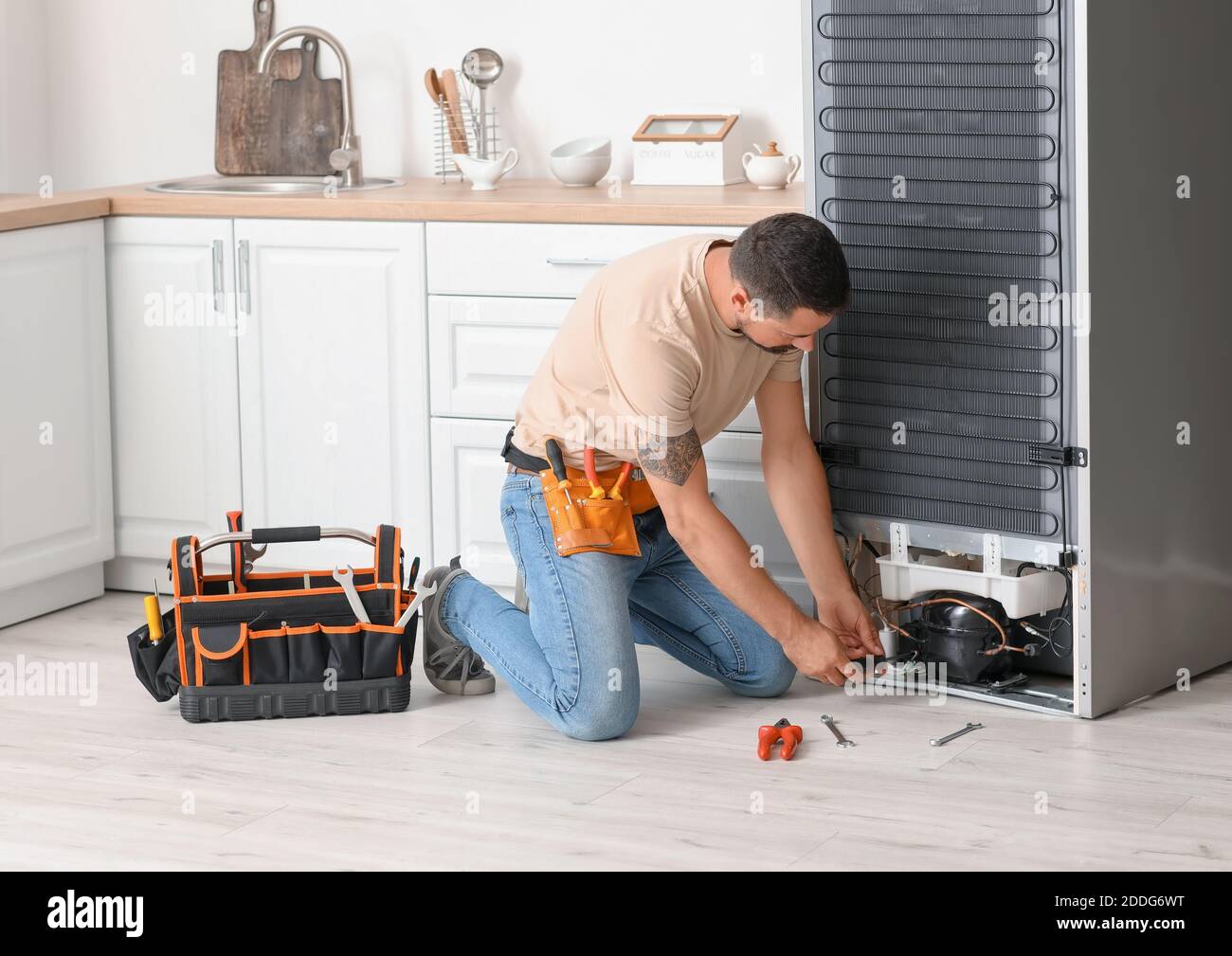Worker repairing fridge in hi-res stock photography and images - Alamy