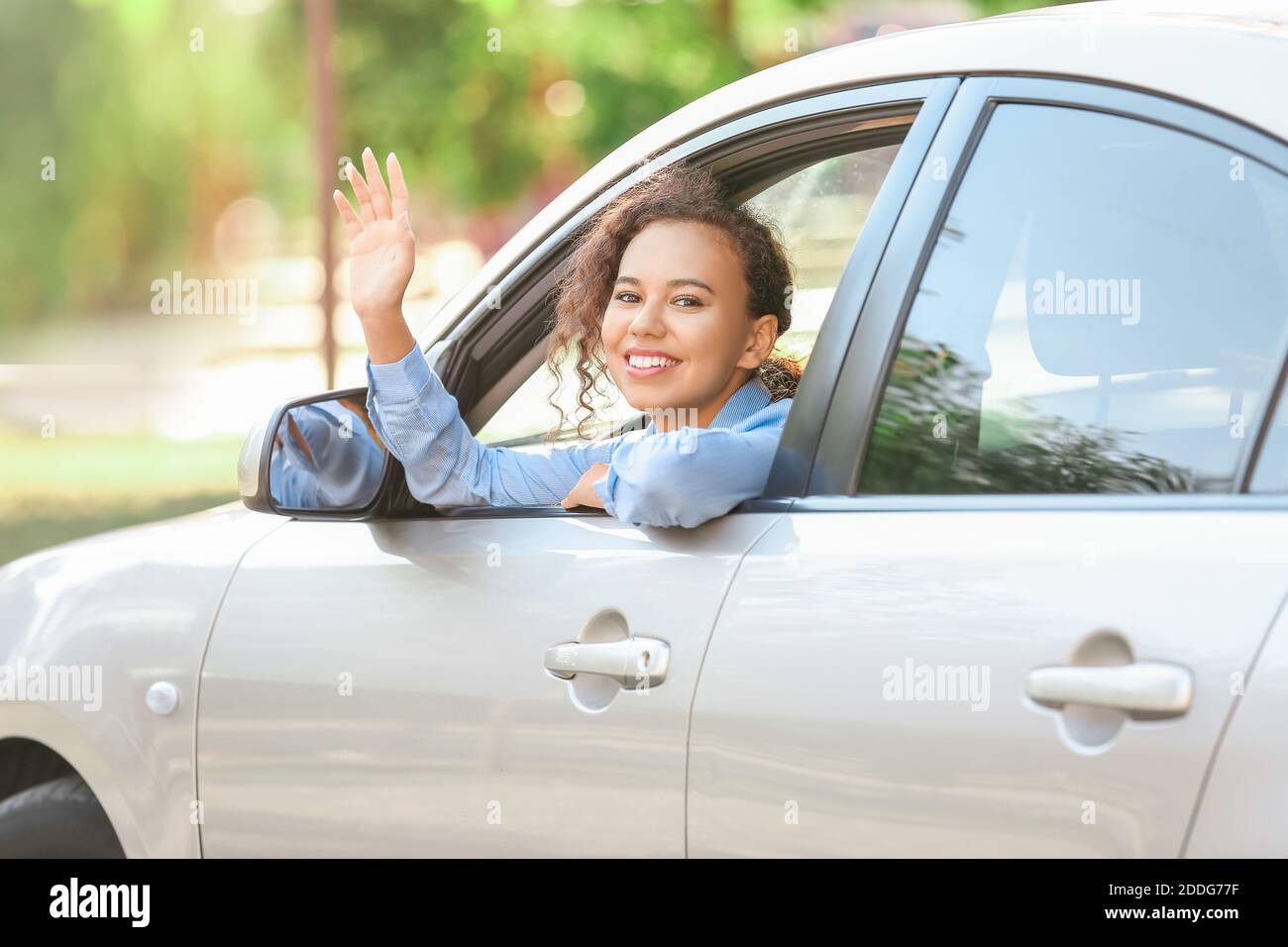 Happy African-American woman looking out of car window Stock Photo - Alamy