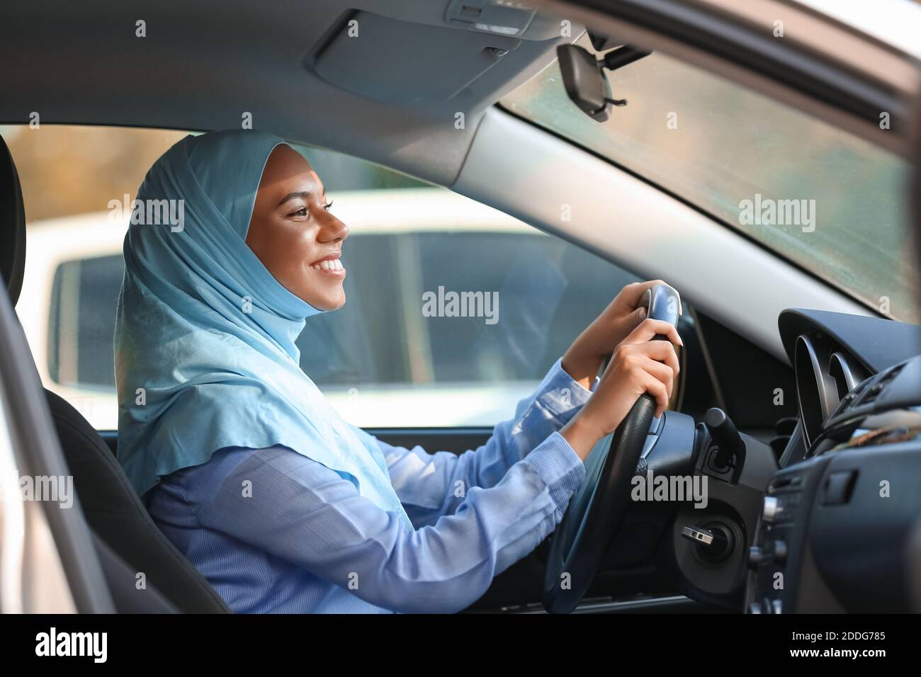 Young Muslim woman driving car Stock Photo - Alamy