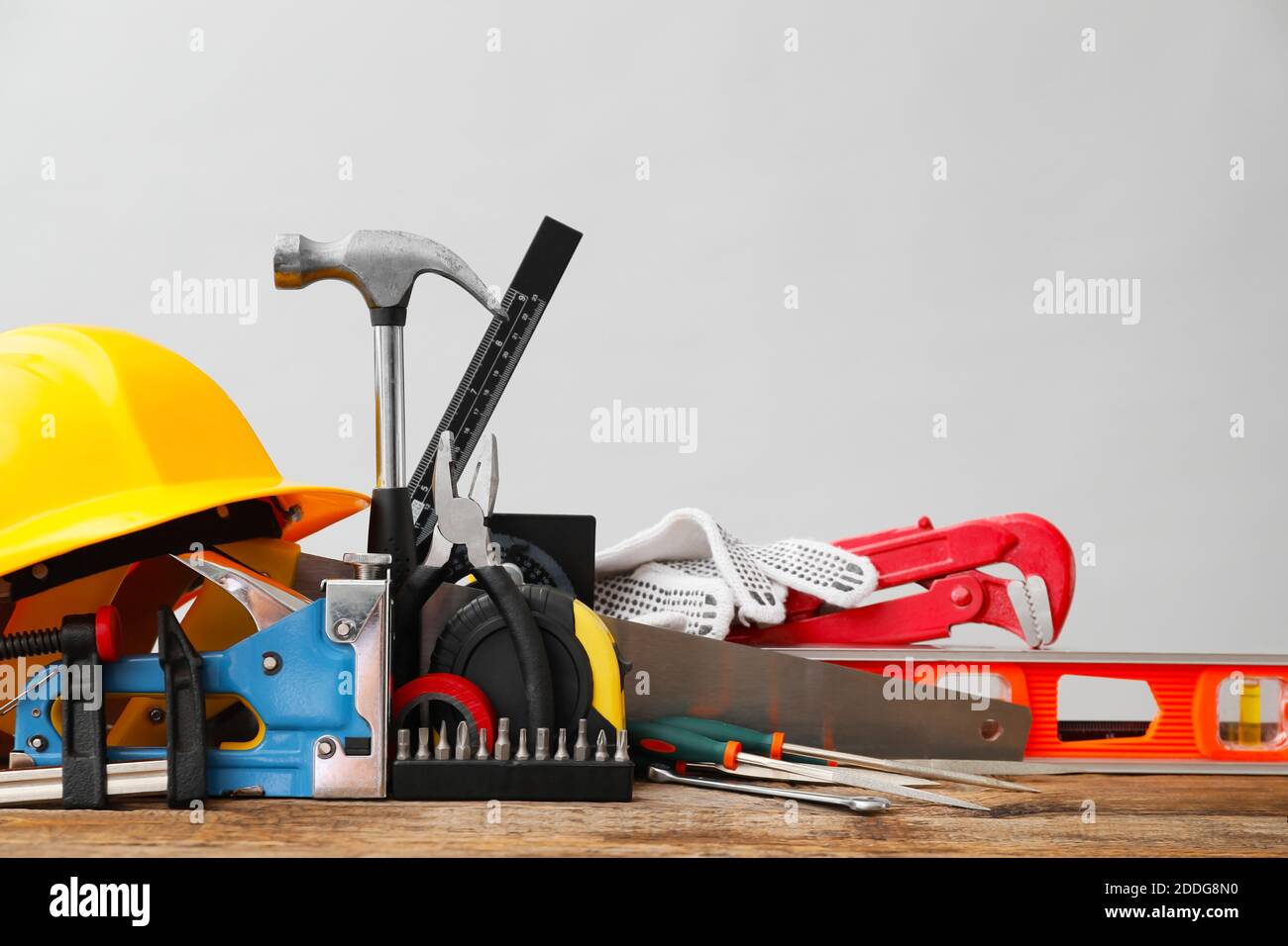Construction tools on table against grey background Stock Photo - Alamy