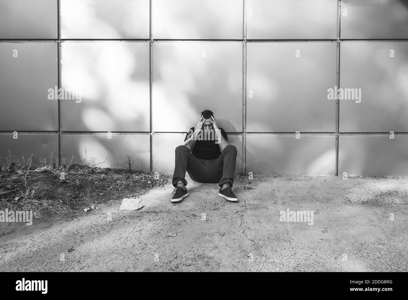 Depressed male junkie sitting outdoors. Concept of addiction Stock ...