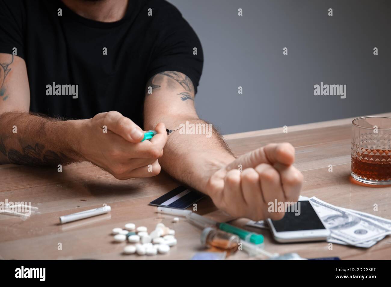 Male junkie making injection at table. Concept of addiction Stock Photo ...