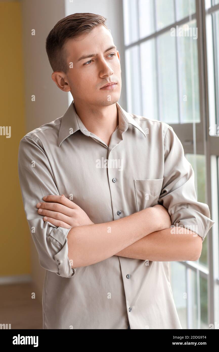 Handsome young man near window at home Stock Photo - Alamy