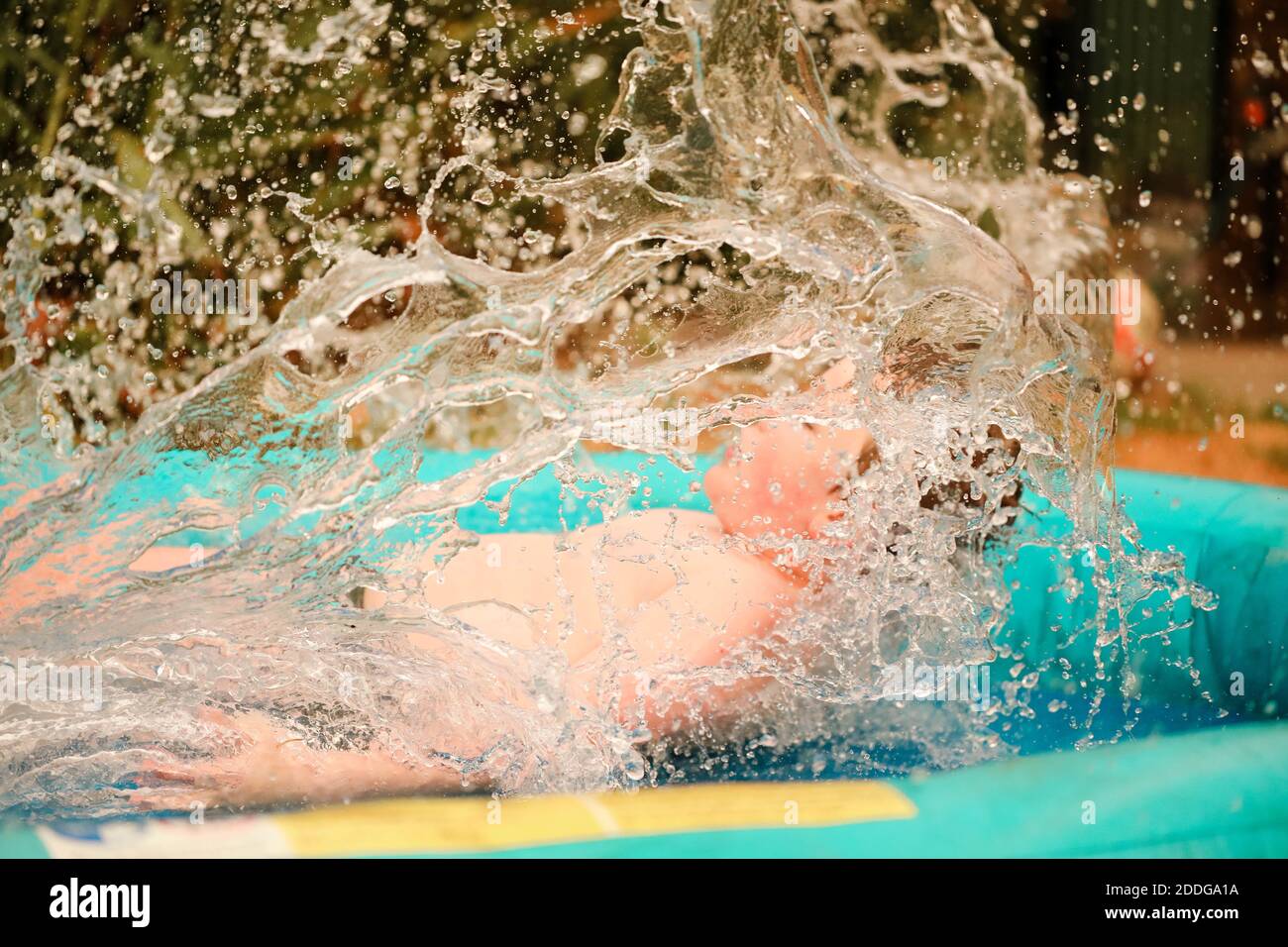 A boy swimming in a pool leaving water splashes Stock Photo - Alamy