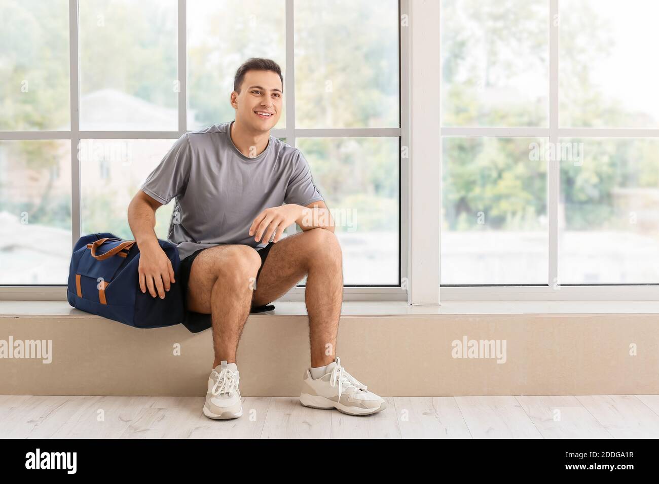 Young man with sports bag in gym Stock Photo - Alamy