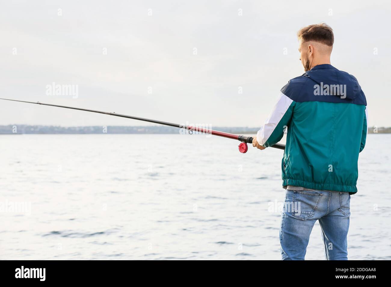 Young man fishing on river Stock Photo - Alamy