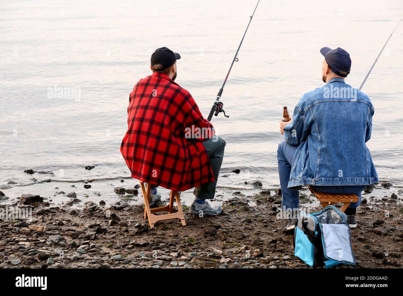 Young men fishing on river Stock Photo - Alamy