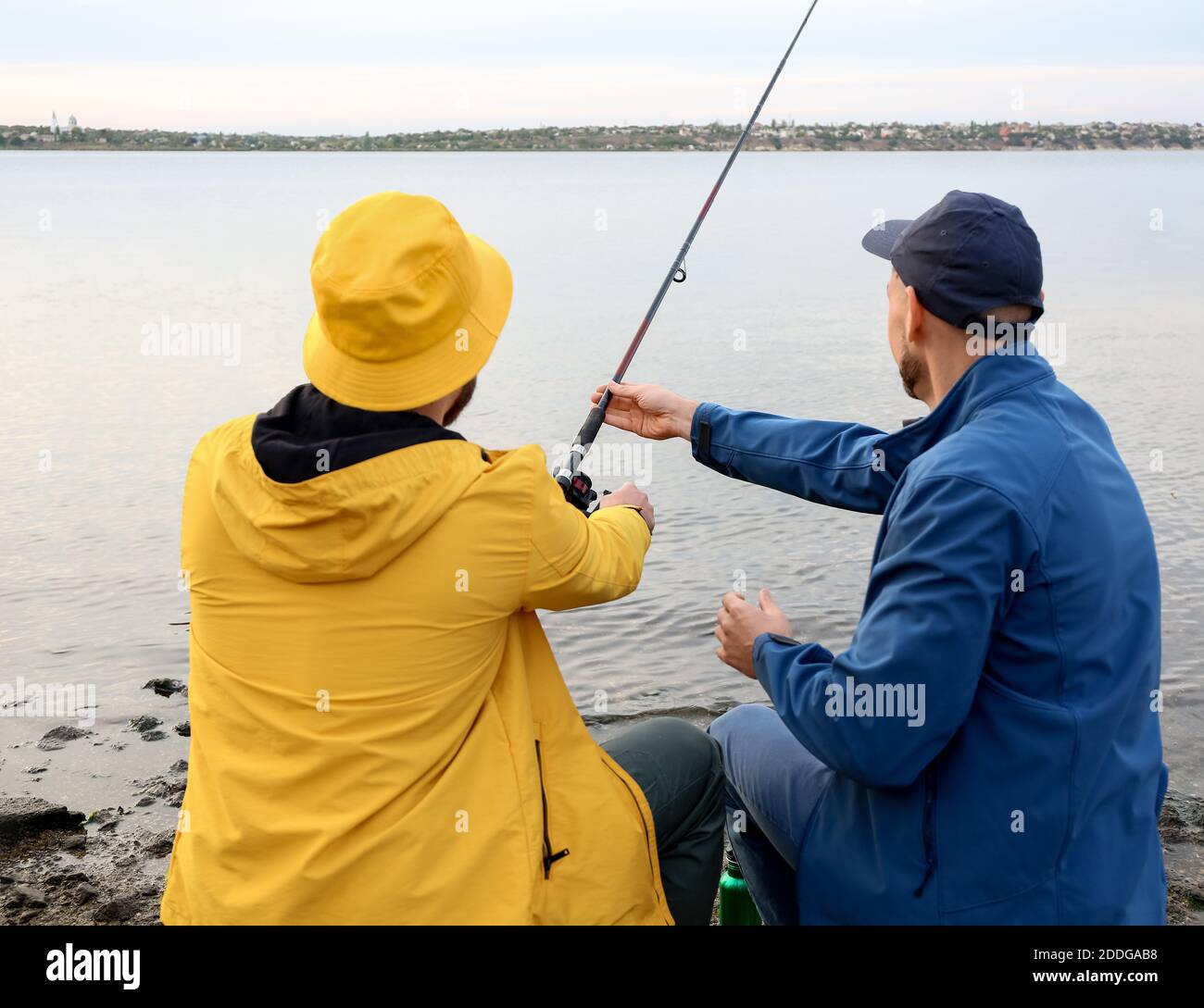 Young men fishing on river Stock Photo - Alamy
