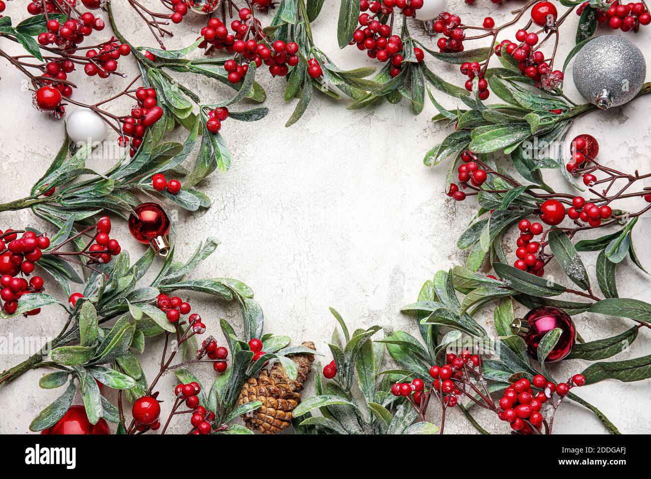 Frame made of mistletoe branches and Christmas decor on white ...