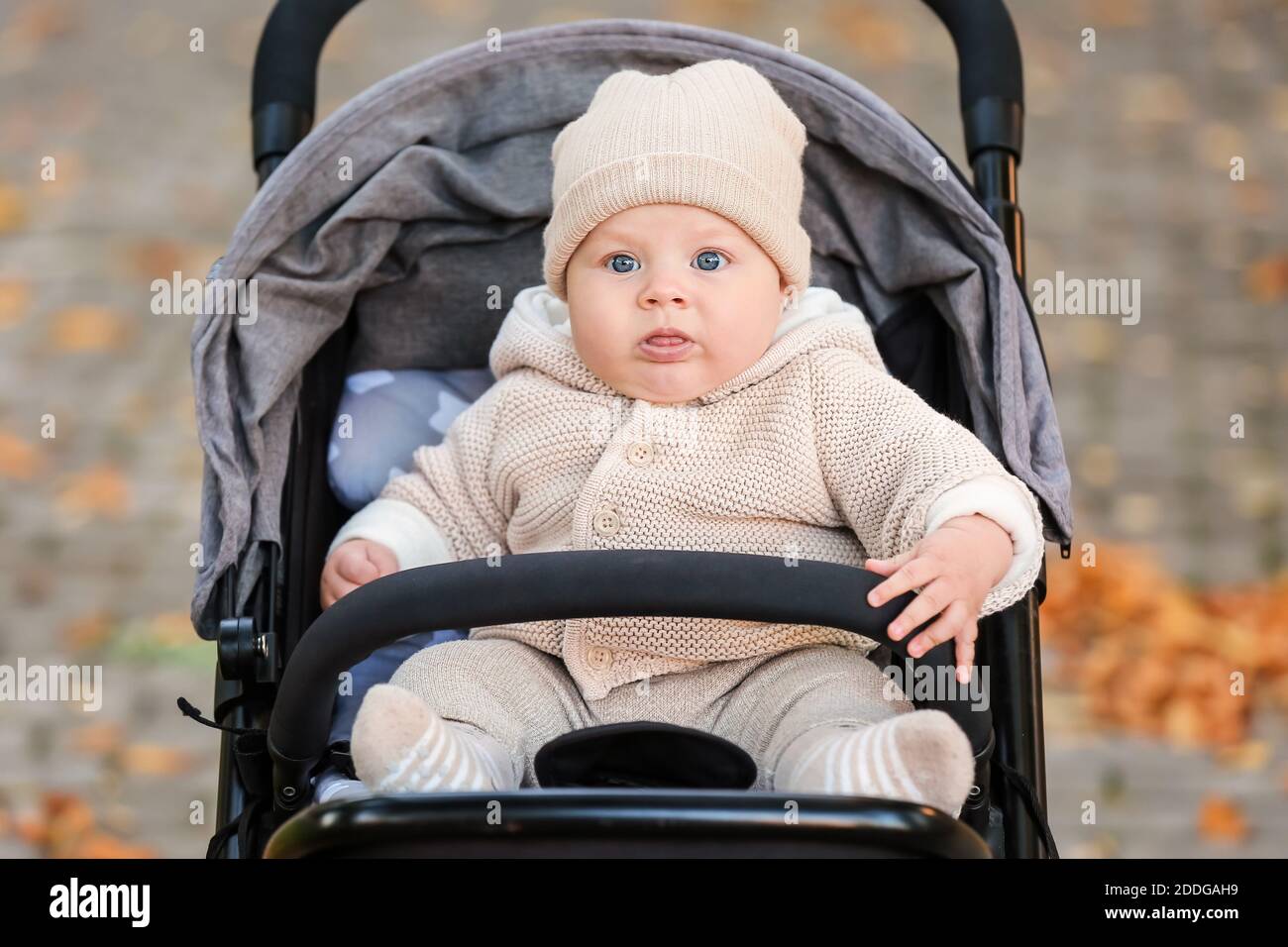 Cute funny baby in stroller outdoors Stock Photo - Alamy
