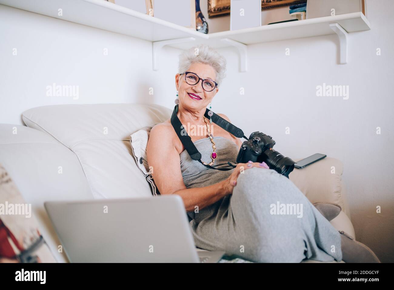 Photographer at home with camera and laptop Stock Photo - Alamy