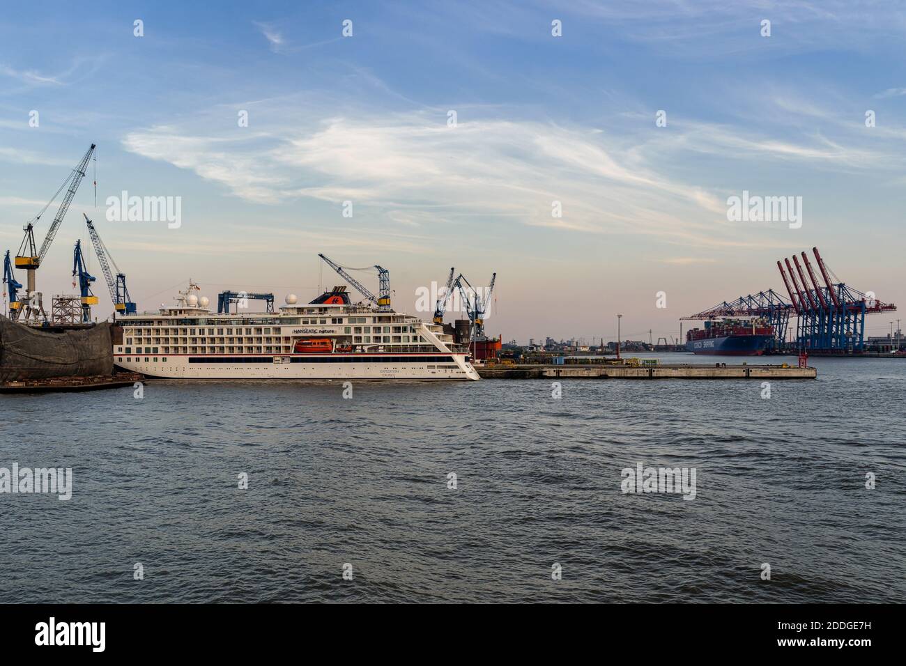View of a cruise ship lying at the docks and a container ship loading ...