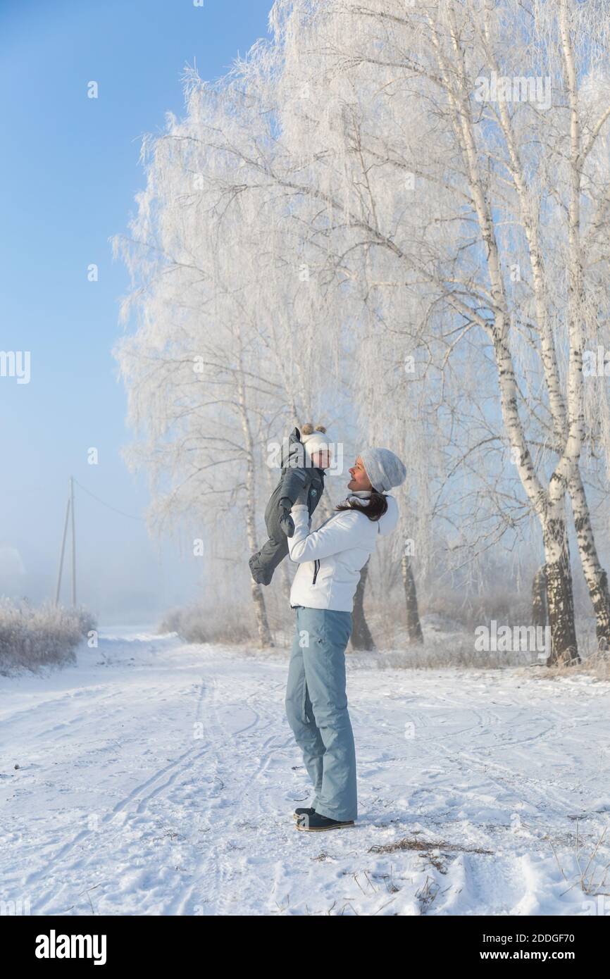 Happy mother and baby is playing on a winter nature walk, Siberia ...