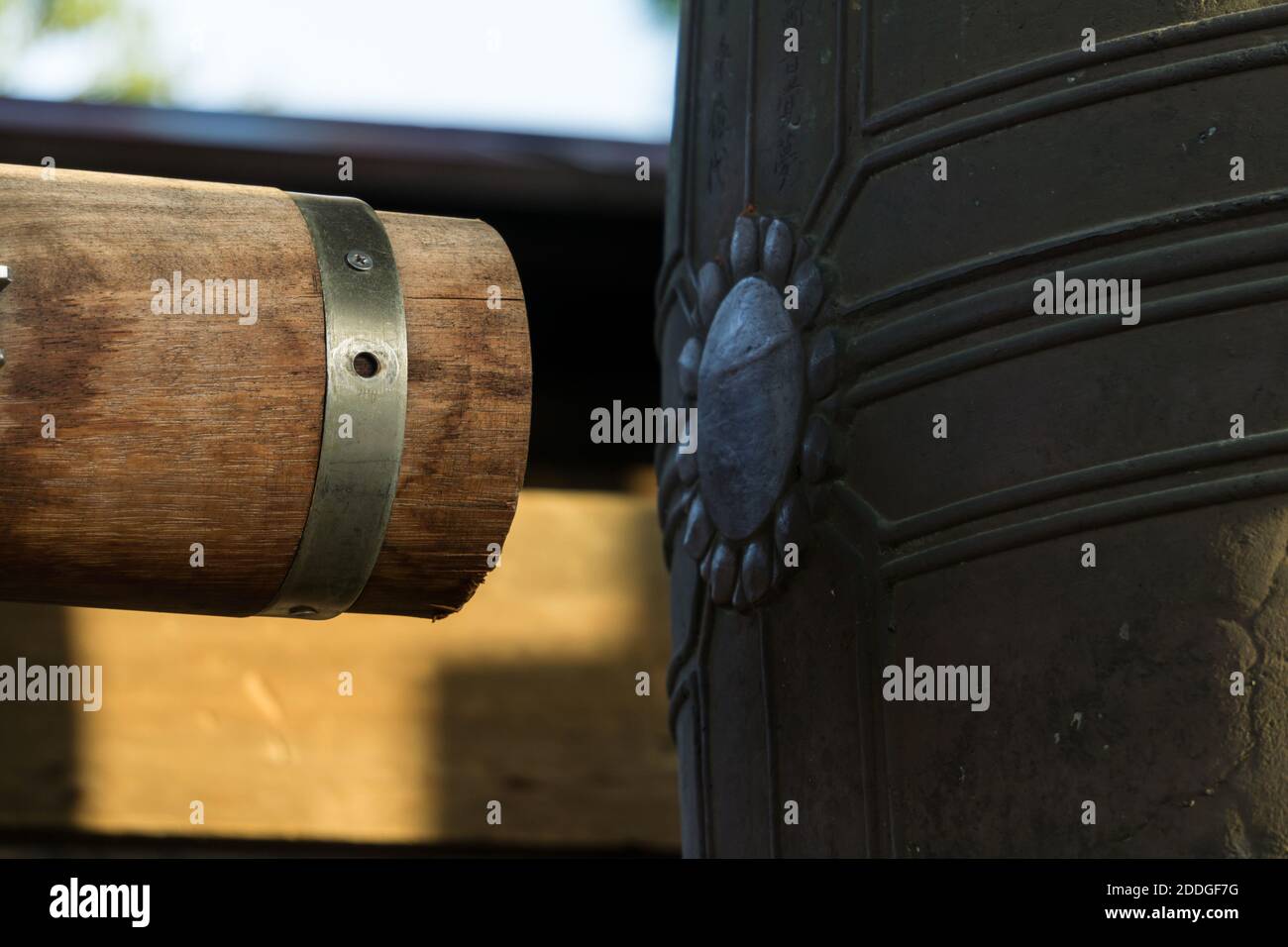 Close up detail of a Japanese copper temple bell and wooden striker at ...