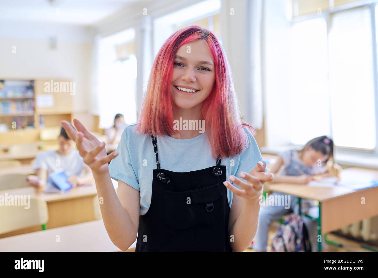 Talking gesturing smiling teenage student at lesson in classroom Stock ...