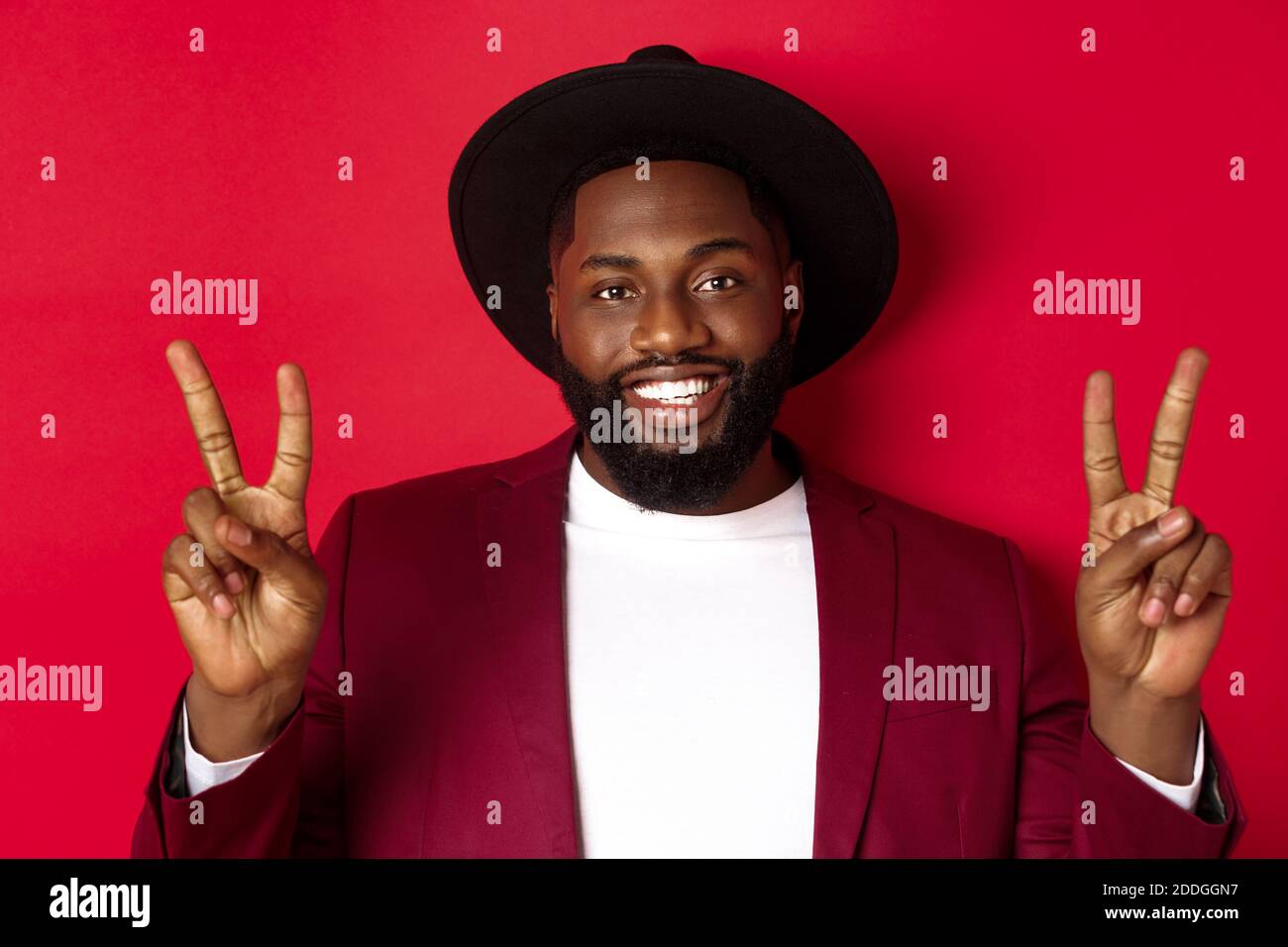 Close-up of handsome bearded Black man showing peace signs and smiling ...