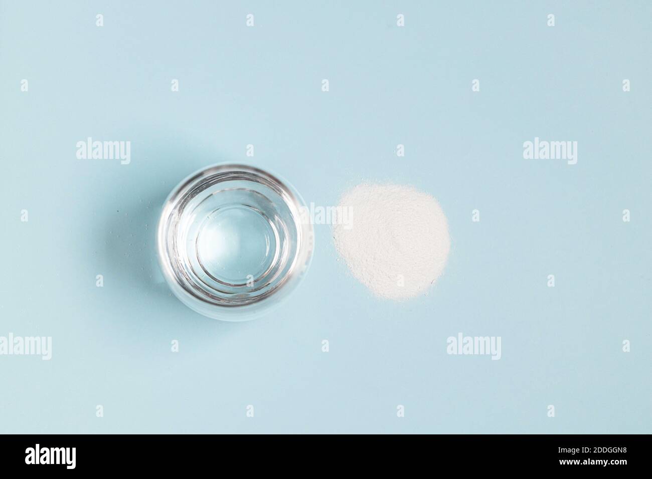 Collagen powder and glass of water on blue background. Horizontal ...