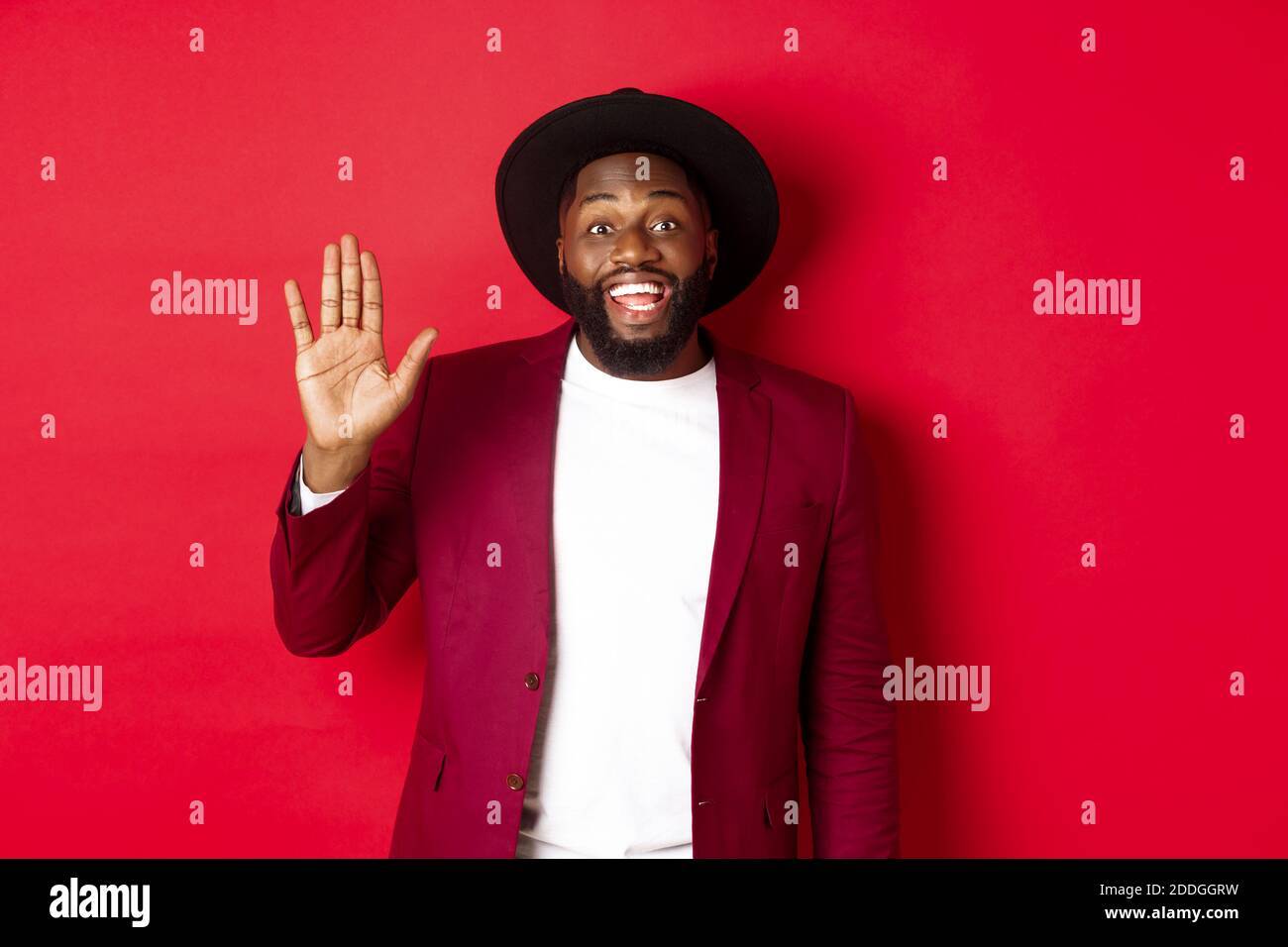 Friendly african american guy waving hand, saying hello and smiling ...