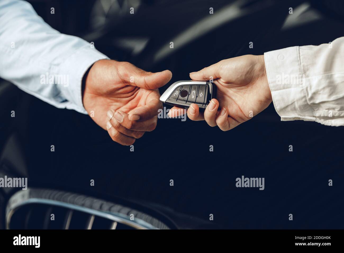 Car salesperson giving keys to a client close up Stock Photo - Alamy