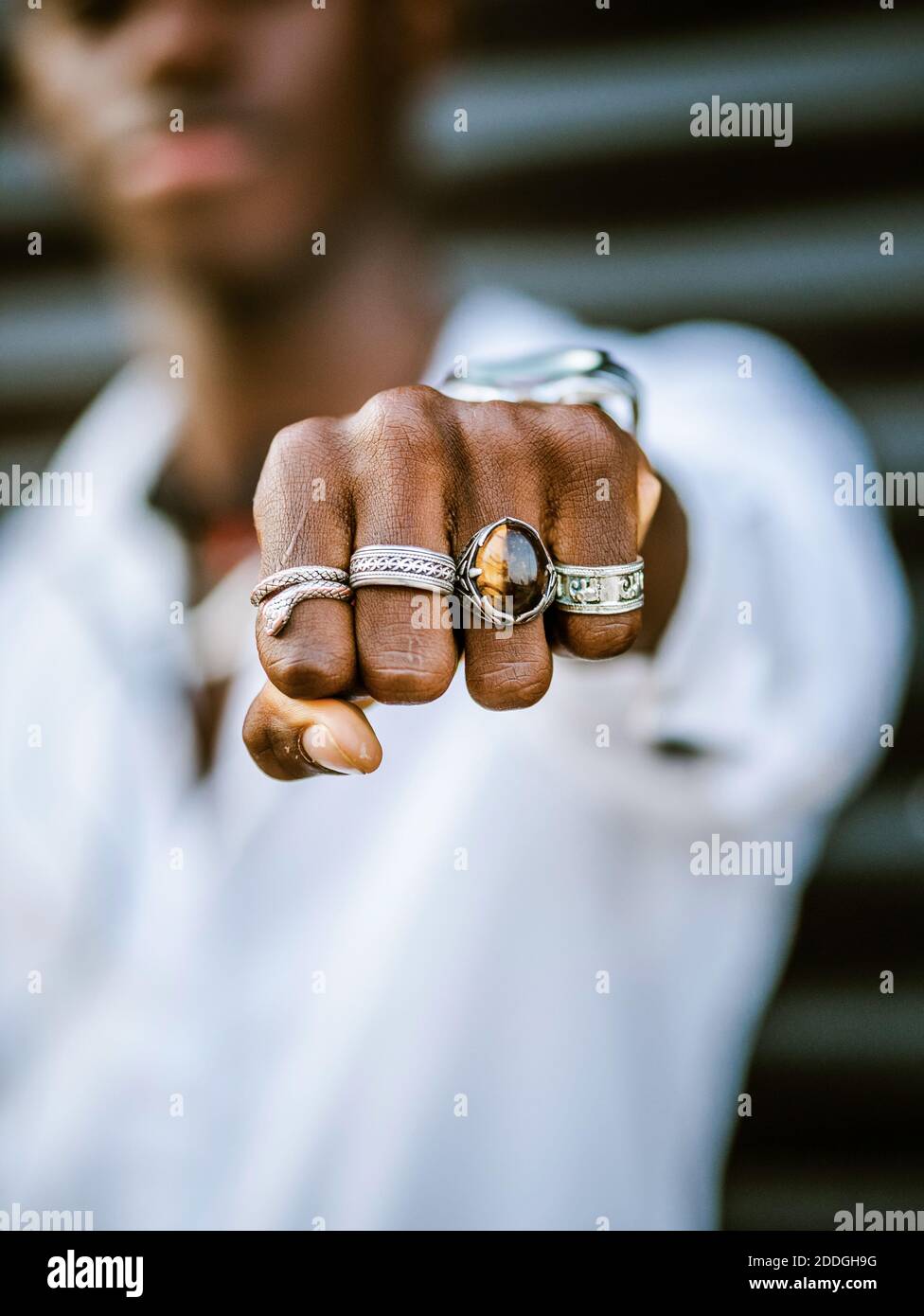 Blurred anonymous African American stylish male showing fist with ...