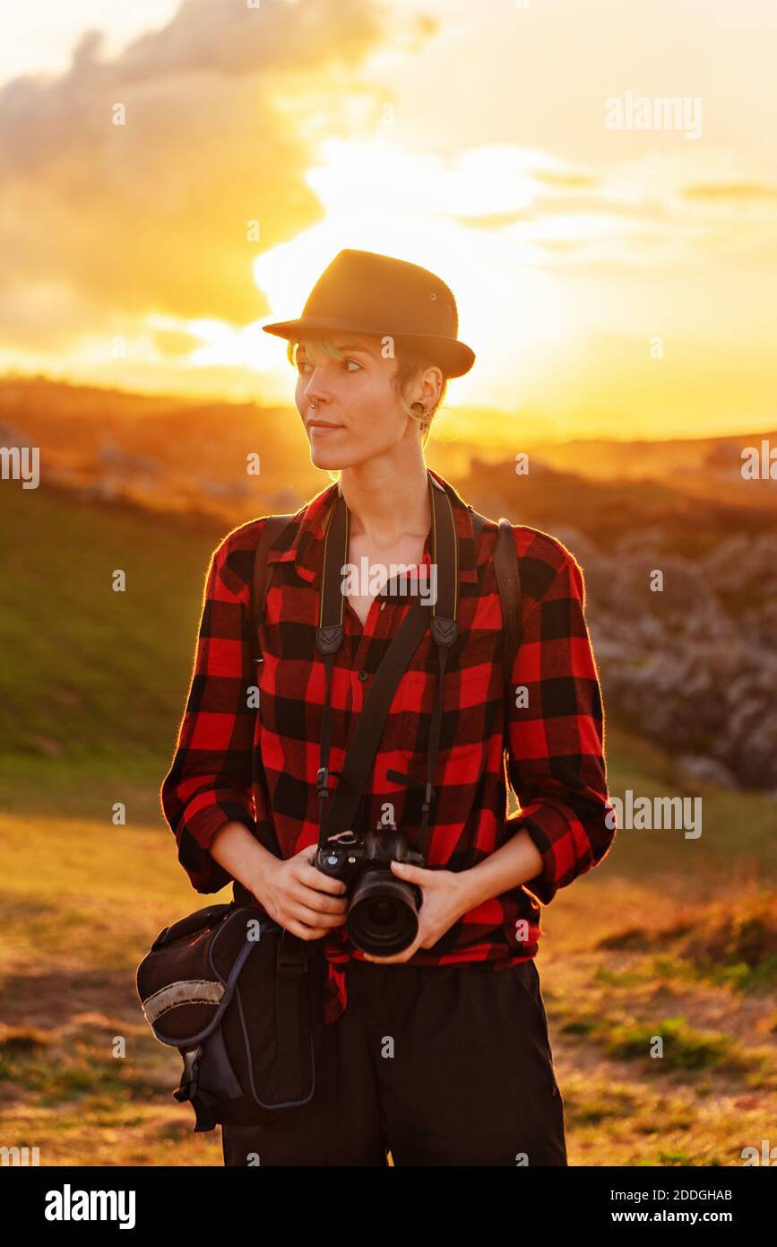Front view of androgynous female traveler with professional photo ...