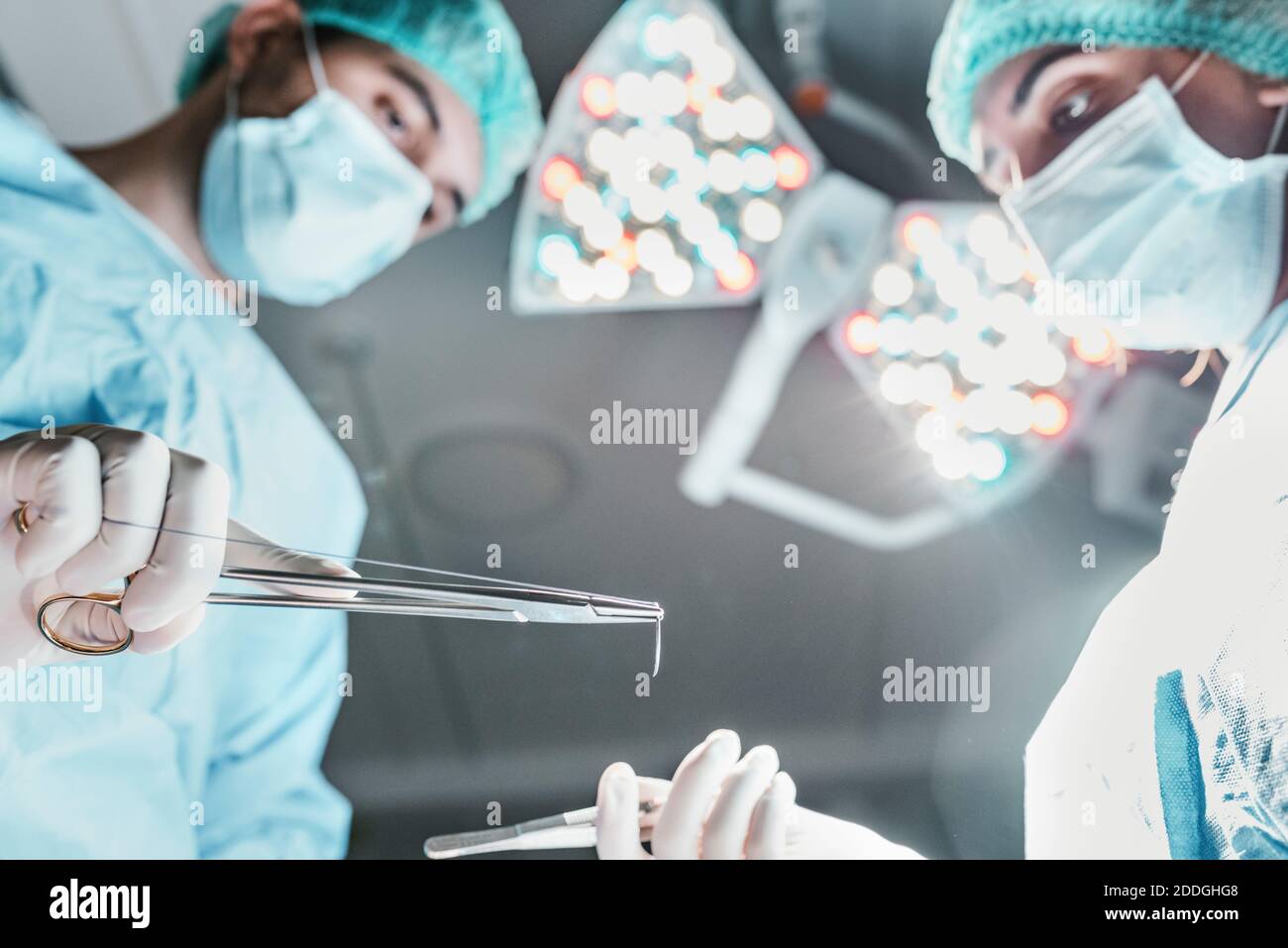 From below side view of focused professional surgeon and nurse with ...