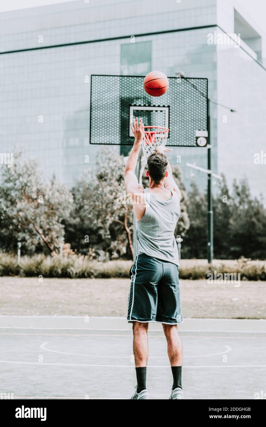 Full body back view of unrecognizable determined young male basketball ...
