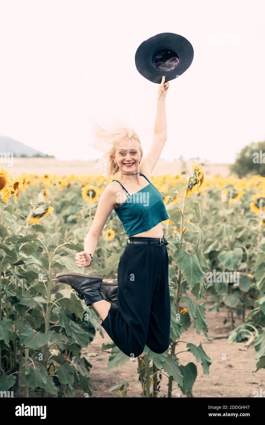 Full body of happy carefree young blonde female in casual outfit with ...