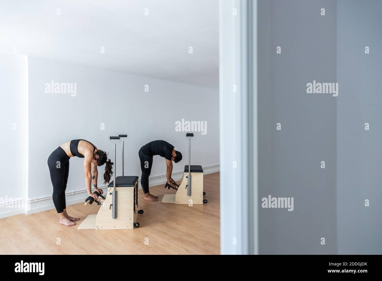 Side view of focused sportsWoman and sportsman stretching body on ...