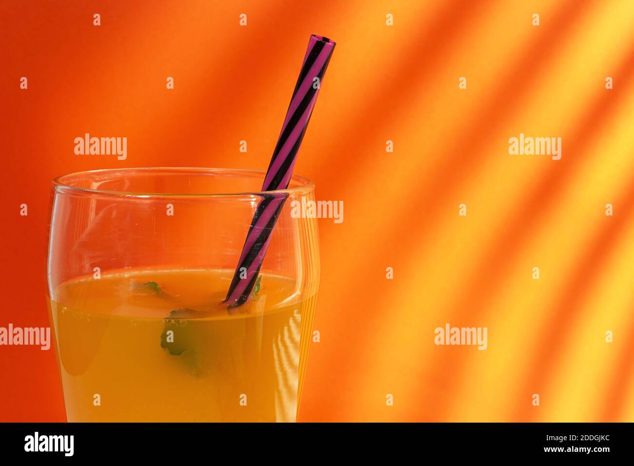 Glass of fresh fruit juice placed on orange background Stock Photo - Alamy