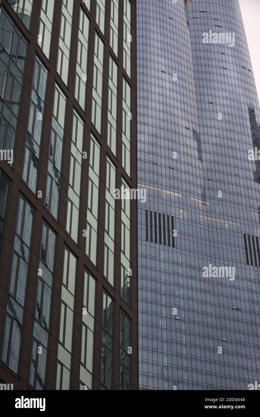 Tall skyscrapers reflecting in glass mirrored facade of high rise ...