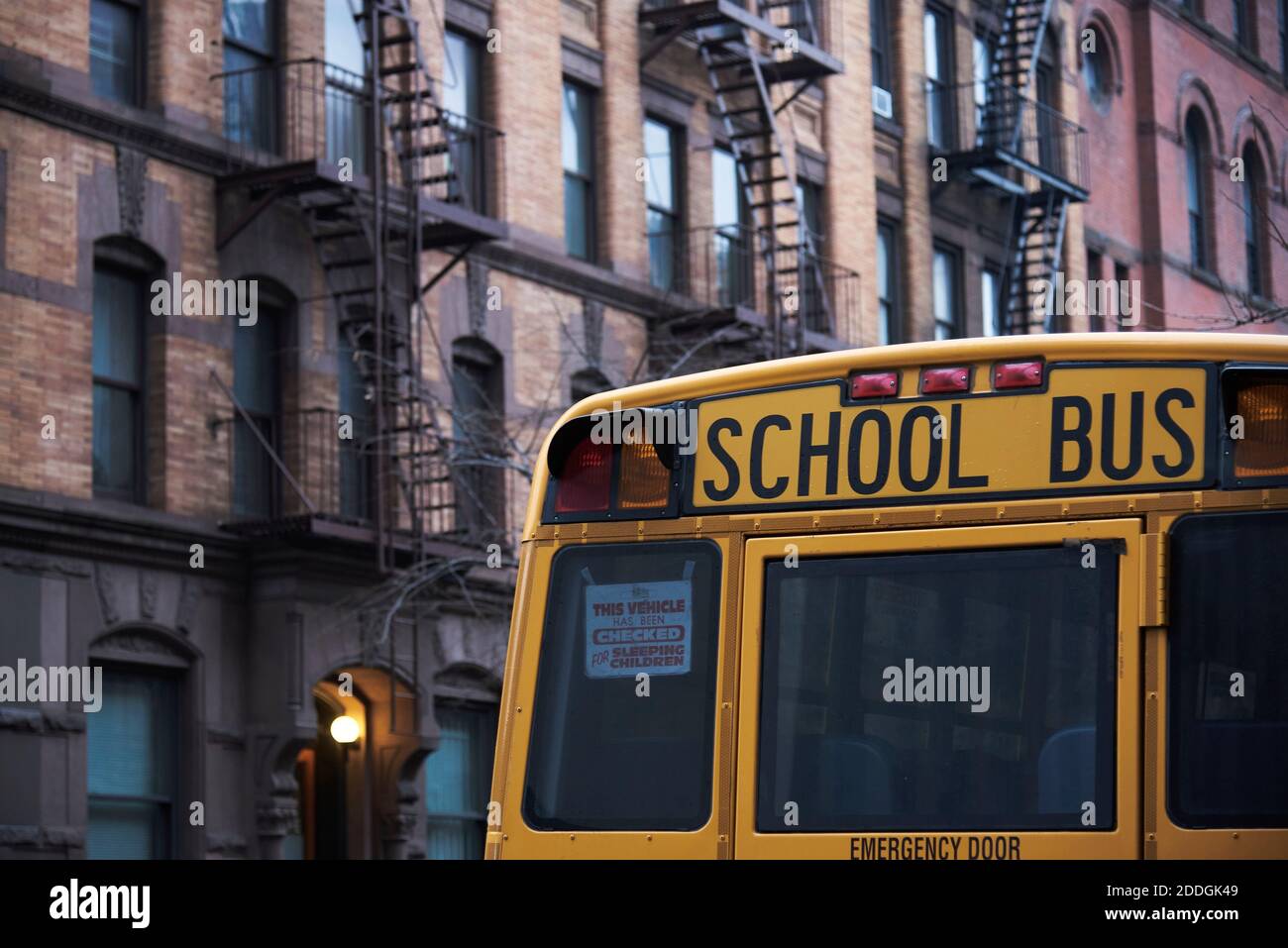 Traditional yellow school bus driving along street in New York city on ...