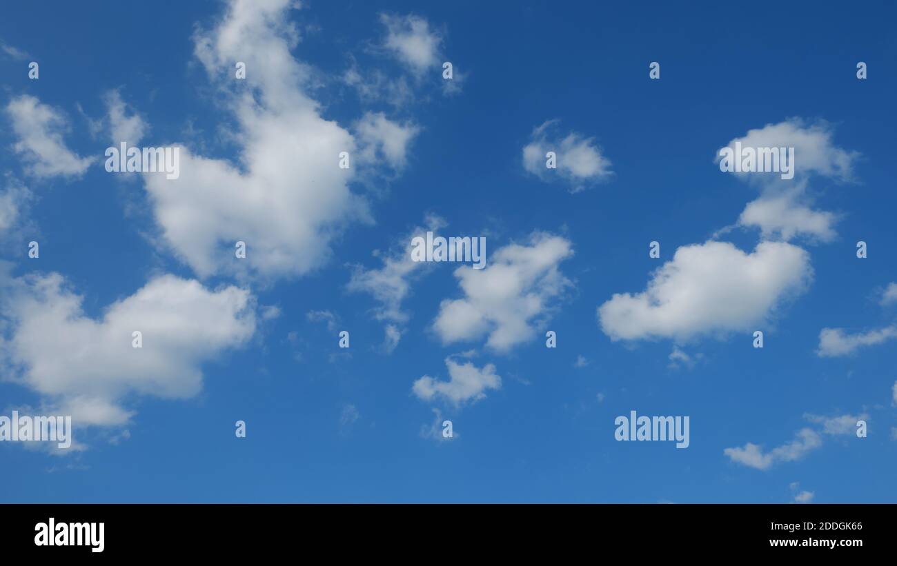 Little cumulus clouds on a blue sky. Background Stock Photo - Alamy