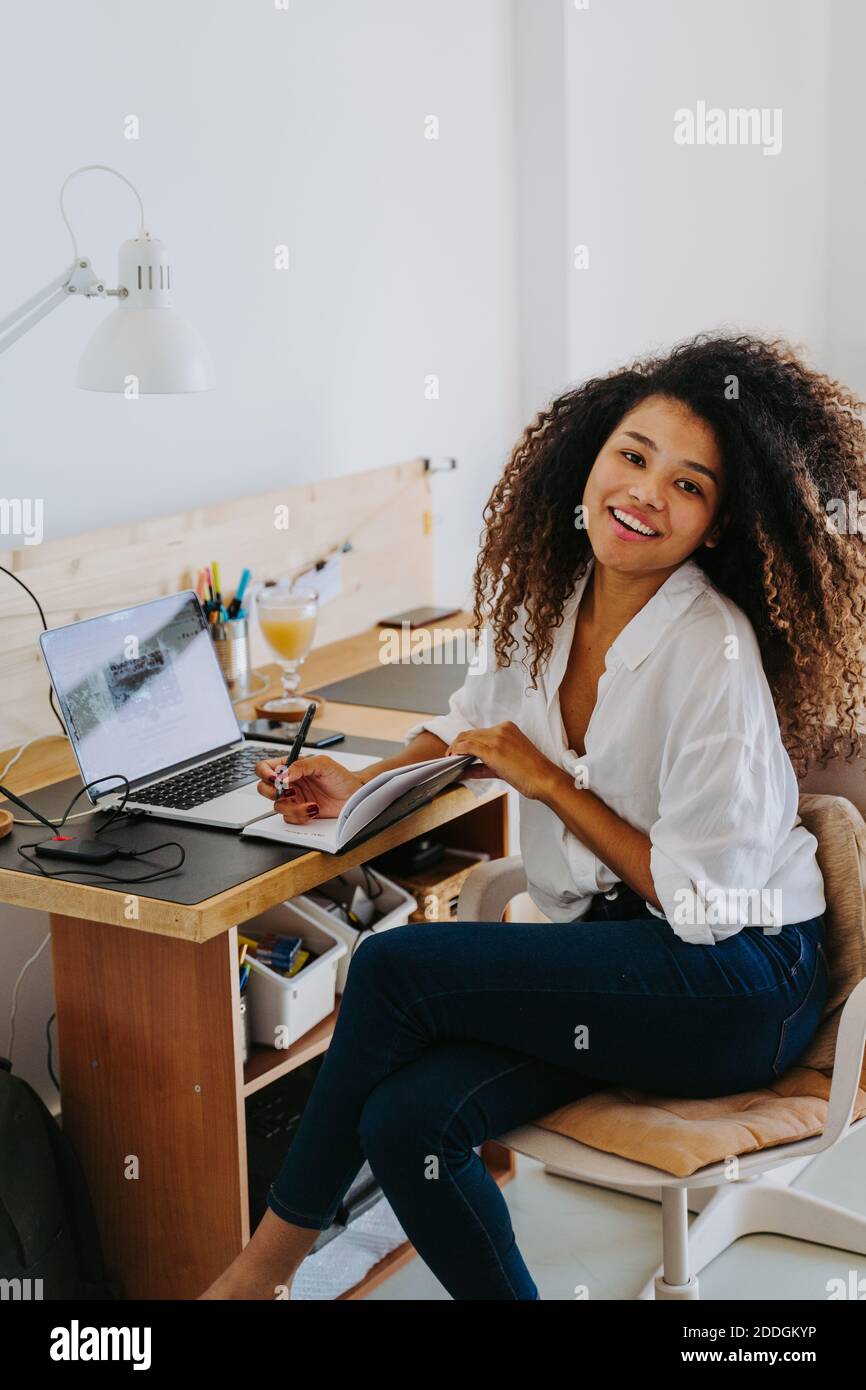Side view of modern young happy African American female remote employee ...