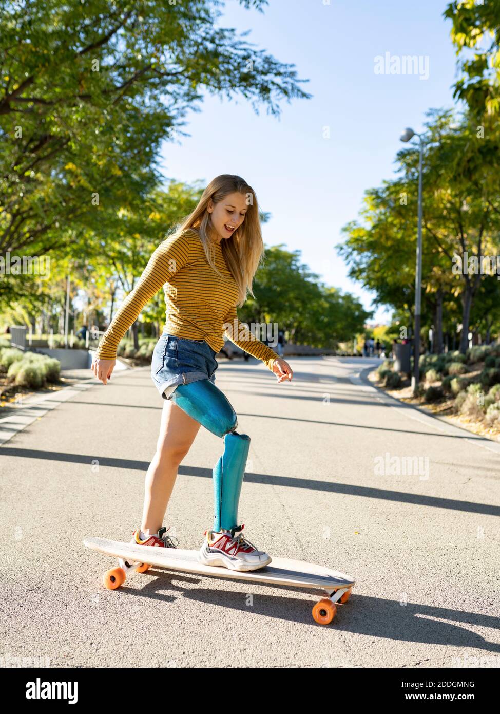 Side view of positive female with leg artificial limb of leg riding ...