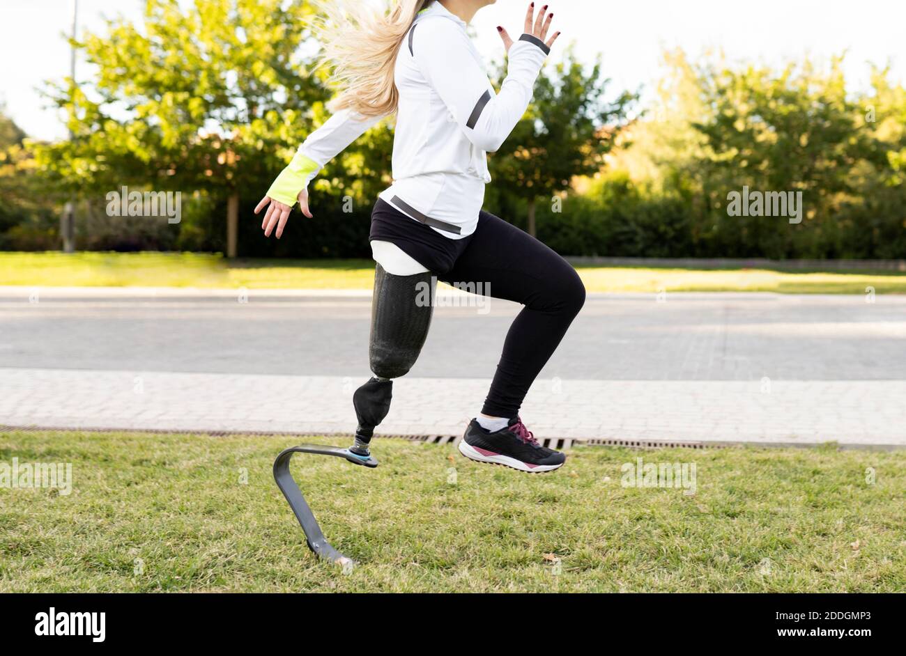Side view of Paralympic female runner with artificial leg doing ...