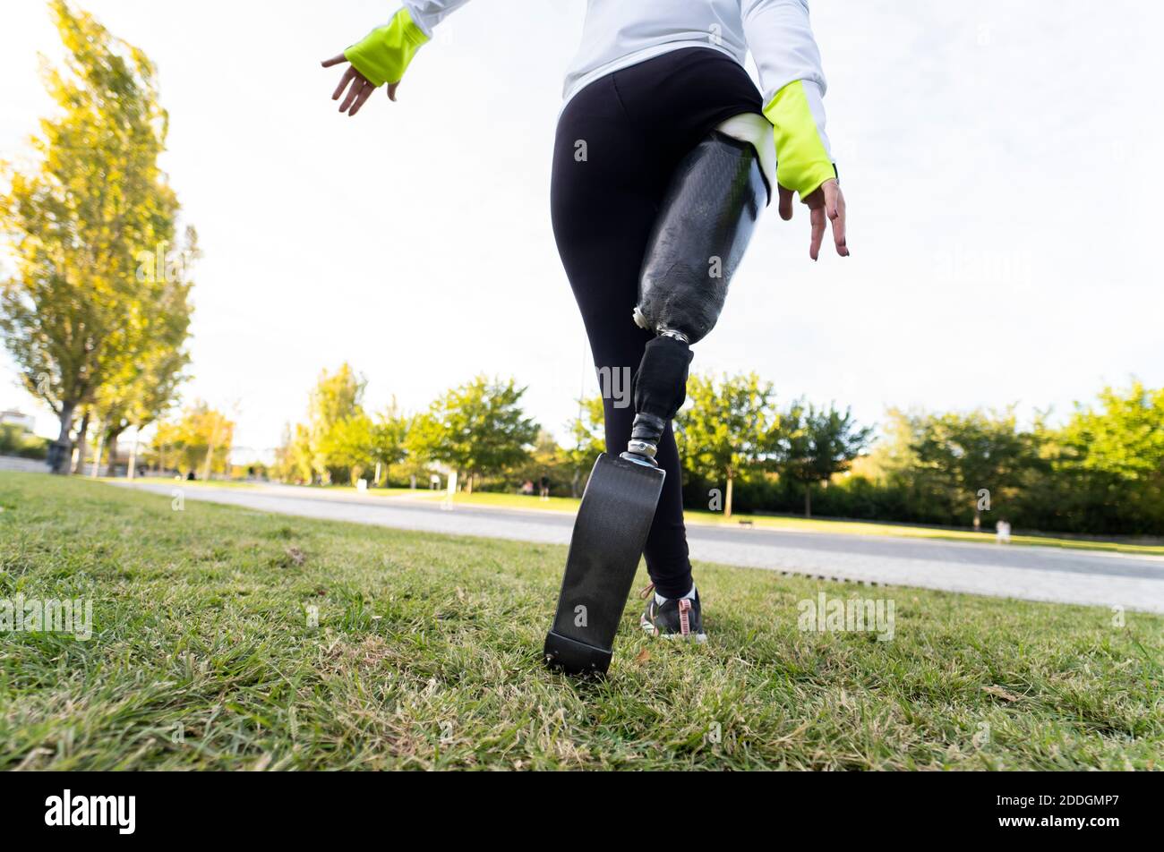 Back view of crop anonymous female runner with leg prosthesis ...