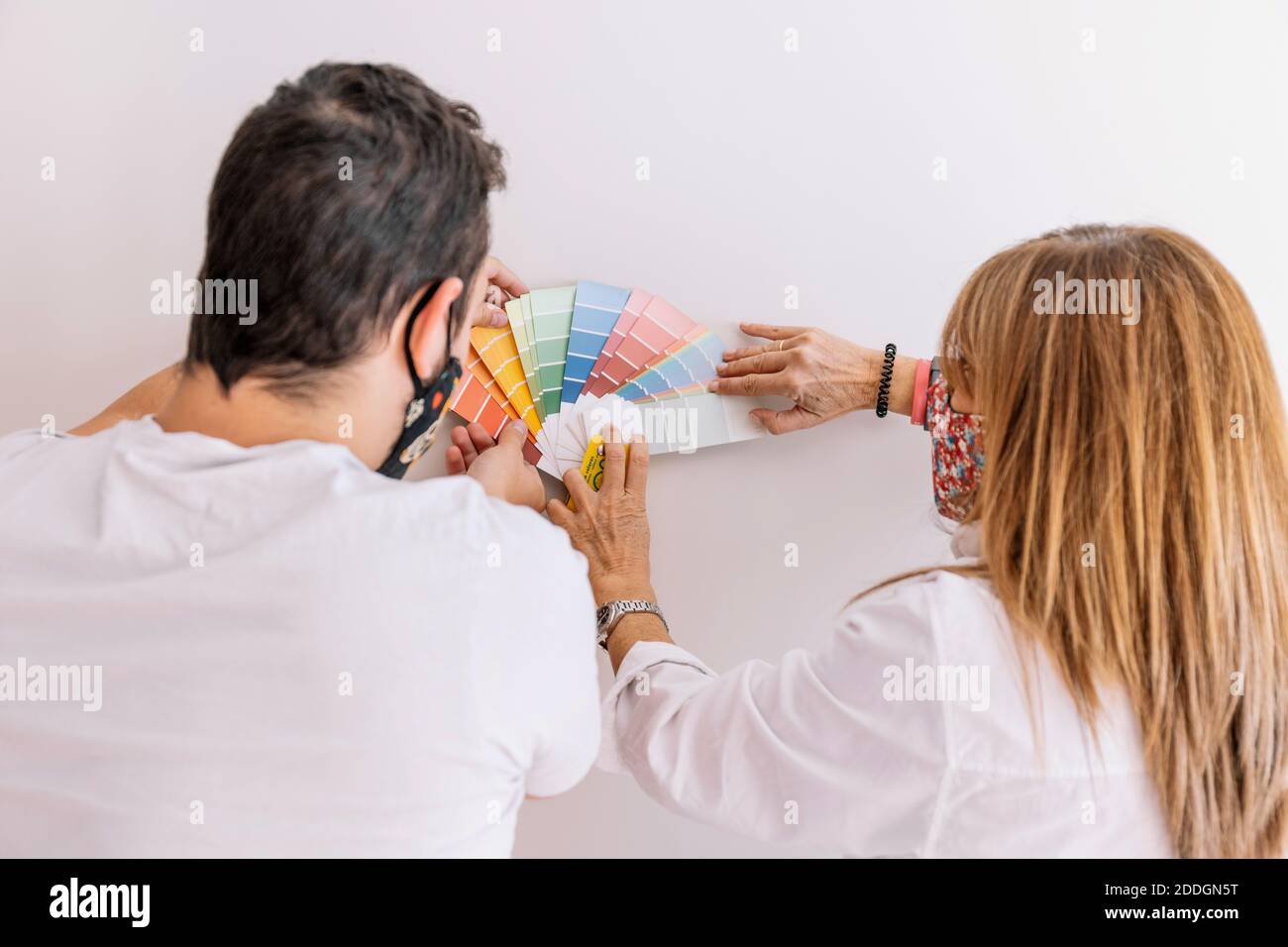 Back view of male worker and Woman with paper palette picking color for ...
