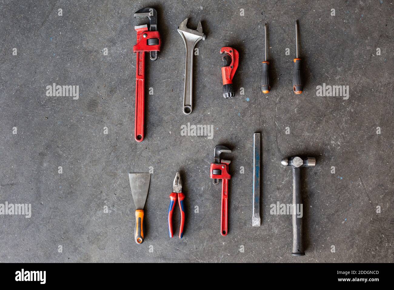 Top view of shabby metal repair tools arranged in rows on floor of ...