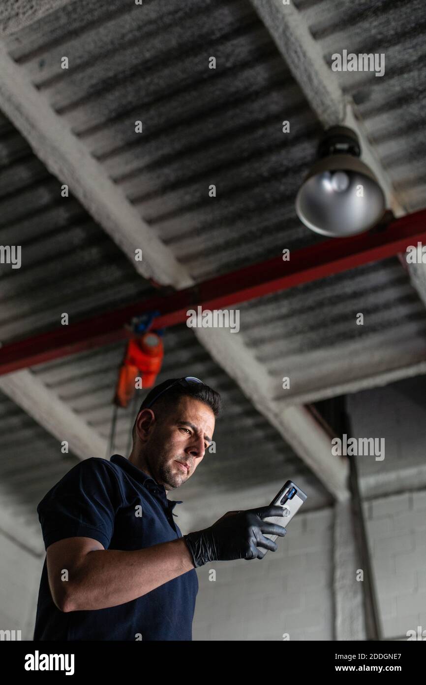 Low angle side view of serious professional repairman in gloves ...