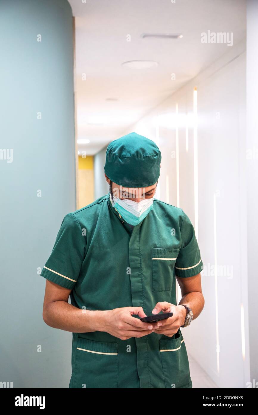 Side view of male hiker hanging Buddhist prayer flag on rope during ...