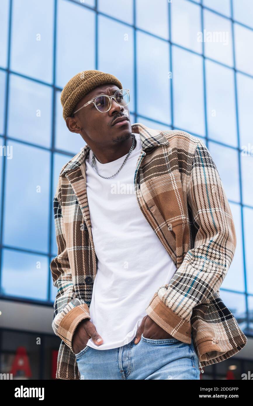 Side view of young African American female driver tuning radio in ...