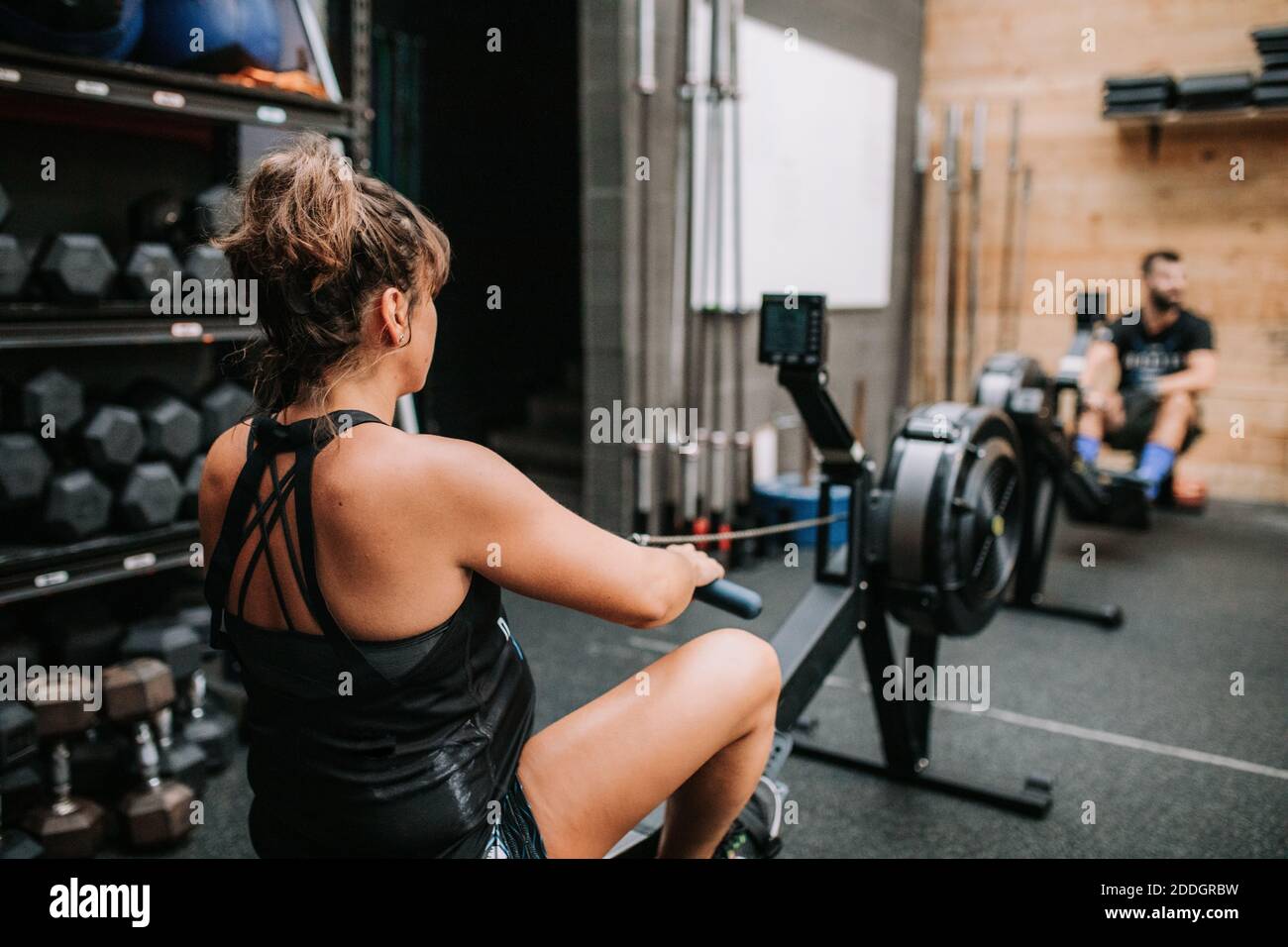 Back view of unrecognizable pregnant female athlete training on rowing ...