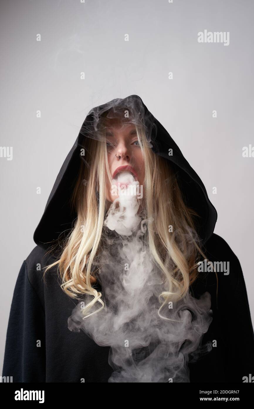 Young woman exhaling smoke hi-res stock photography and images - Alamy