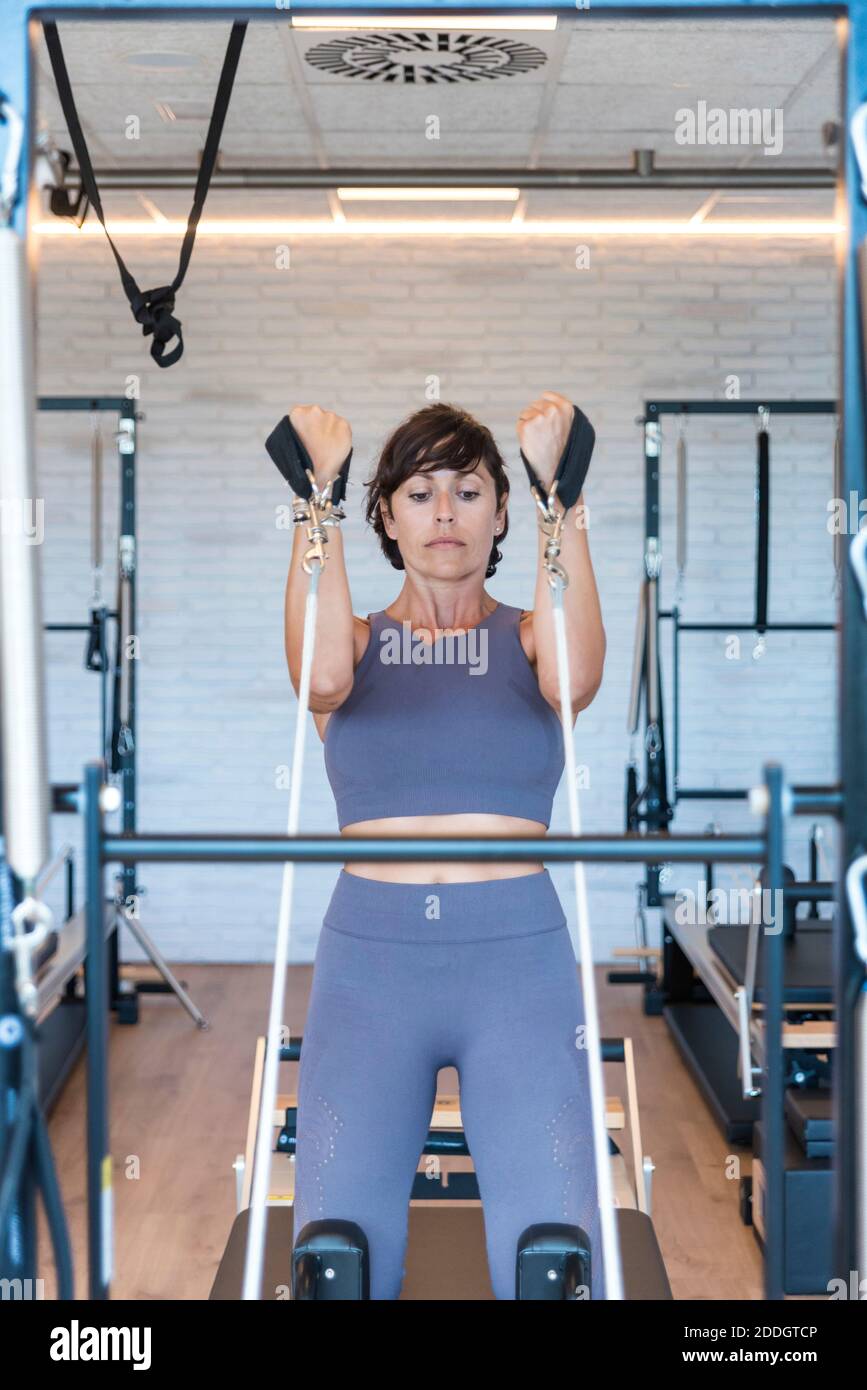 Fit Woman in sportswear pulling resistance ropes and doing Kneeling ...