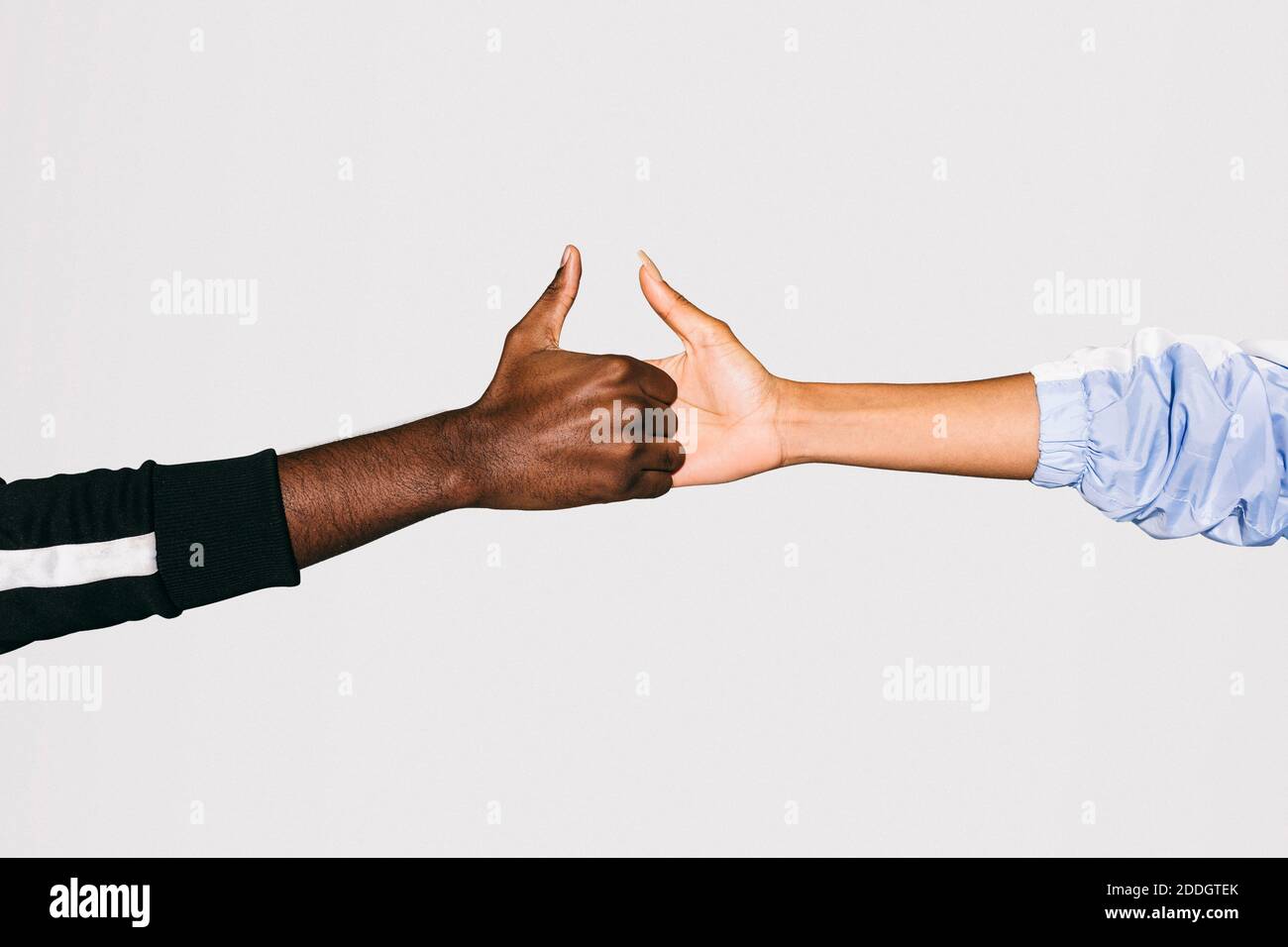 Close-up of a black man's hand holding a white Woman's hand over white ...