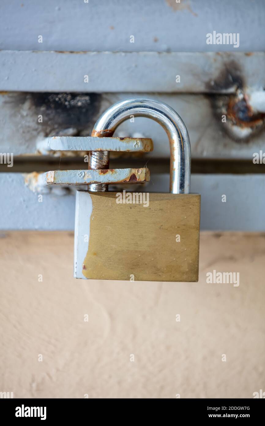 Heavy metal padlock closeup on an entrance gate, vertical closeup view ...