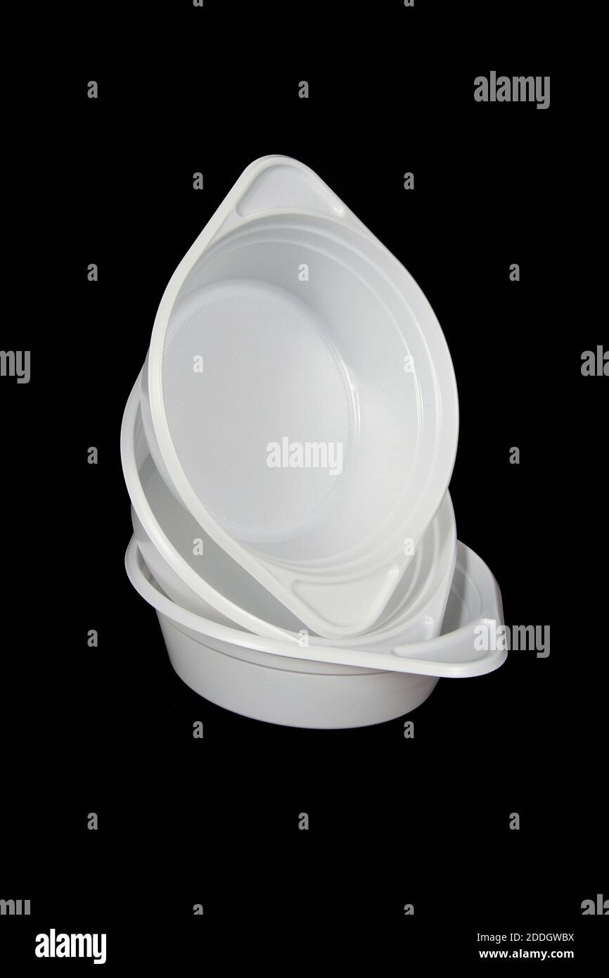 A vertical shot of plastic dishes on black background Stock Photo - Alamy